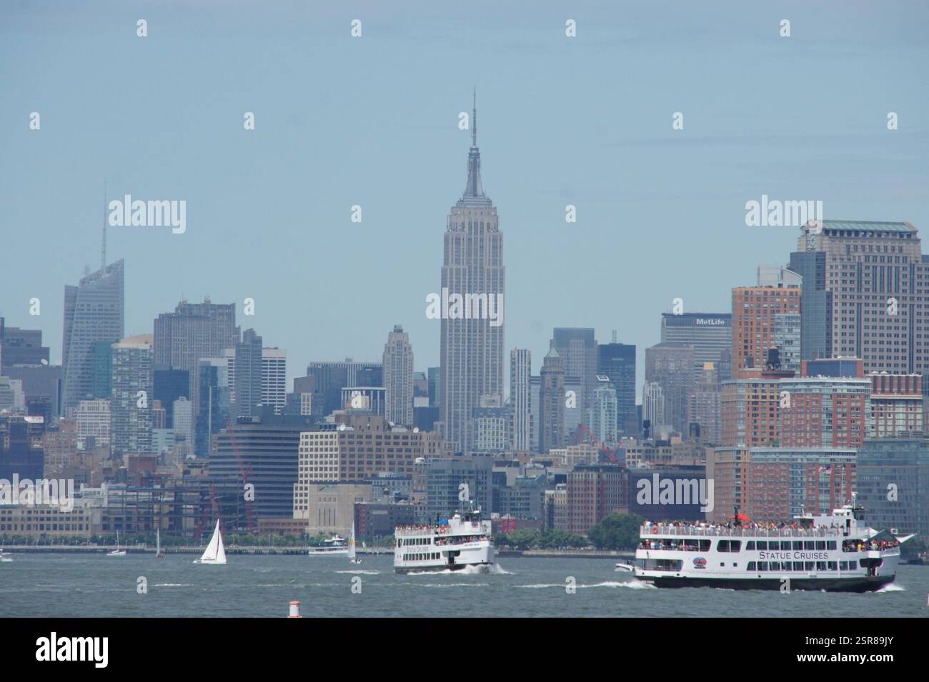 Busy harbor scene in New York, Manhattan. Two tourist boats cruise near ...