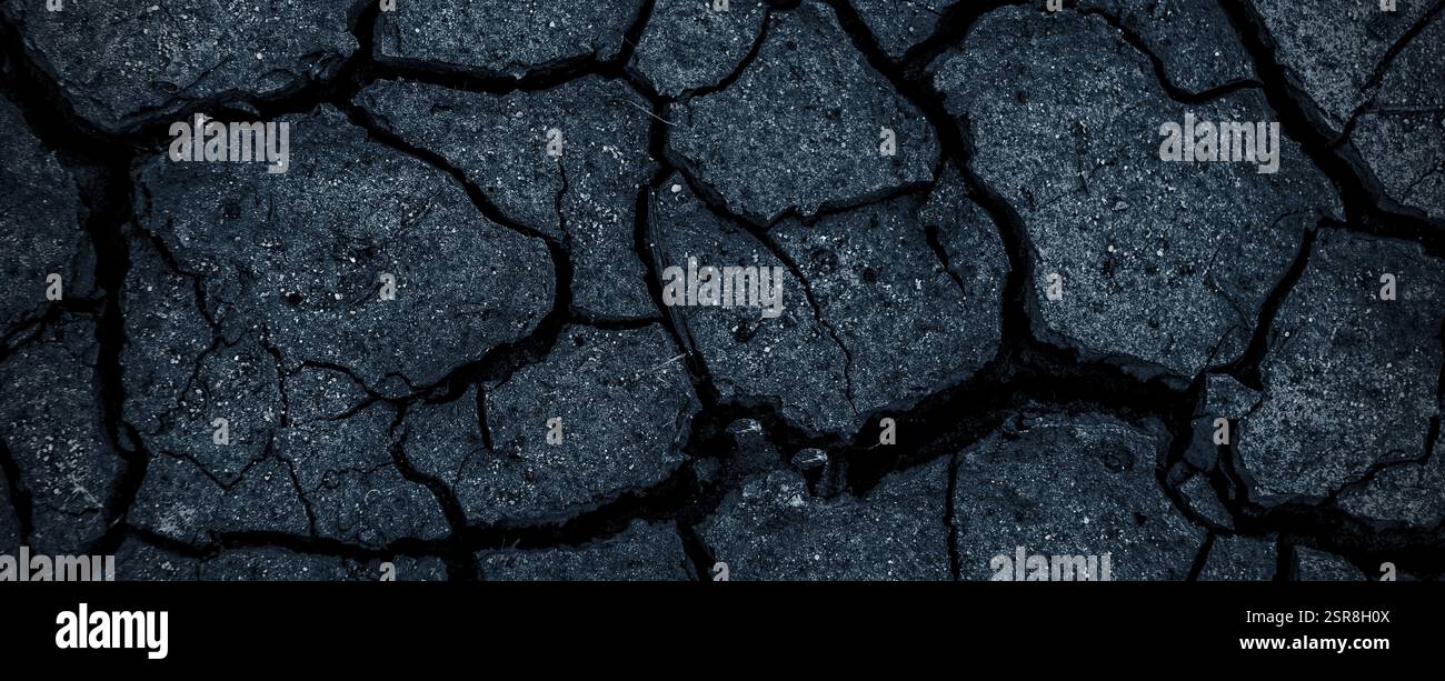 Black ground cracked by hot weather. Global warming and drought concept ...