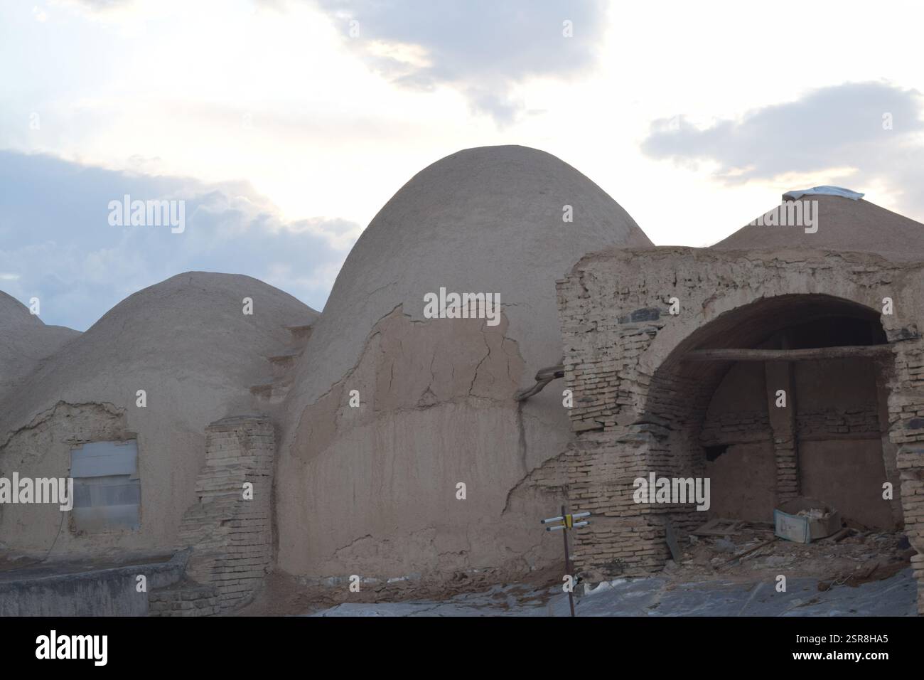 Traditional mud-brick domed house in Iran at sunset, showcasing ...
