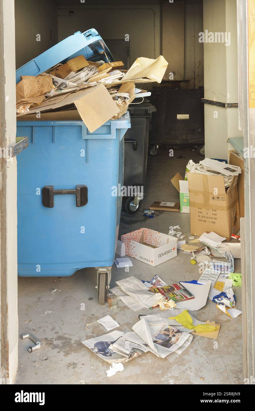 Overfilled blue paper bin, paper waste on the floor Stock Photo - Alamy