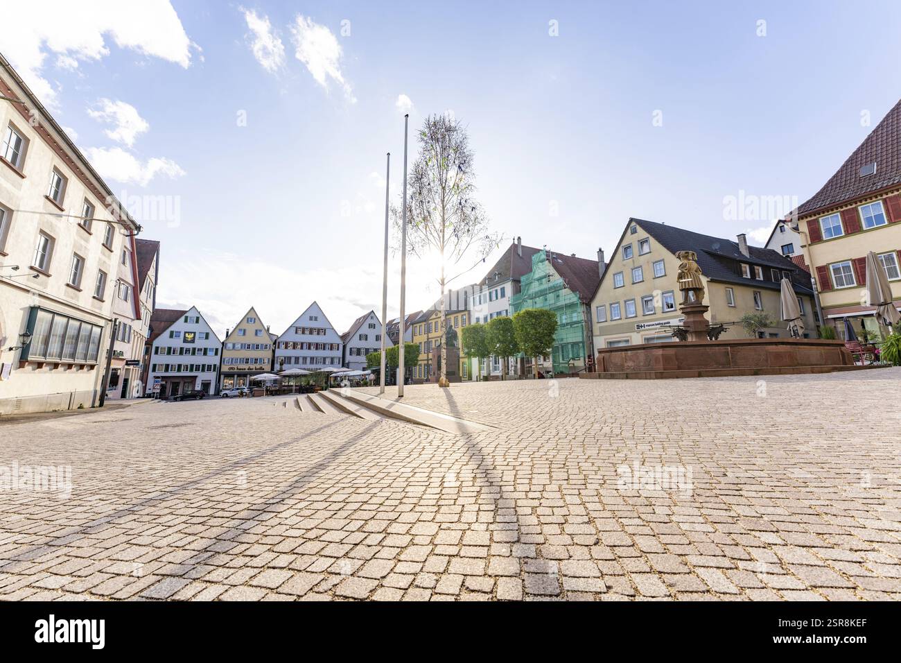 An empty cobbled square with several houses and a quiet, sunny ambience ...