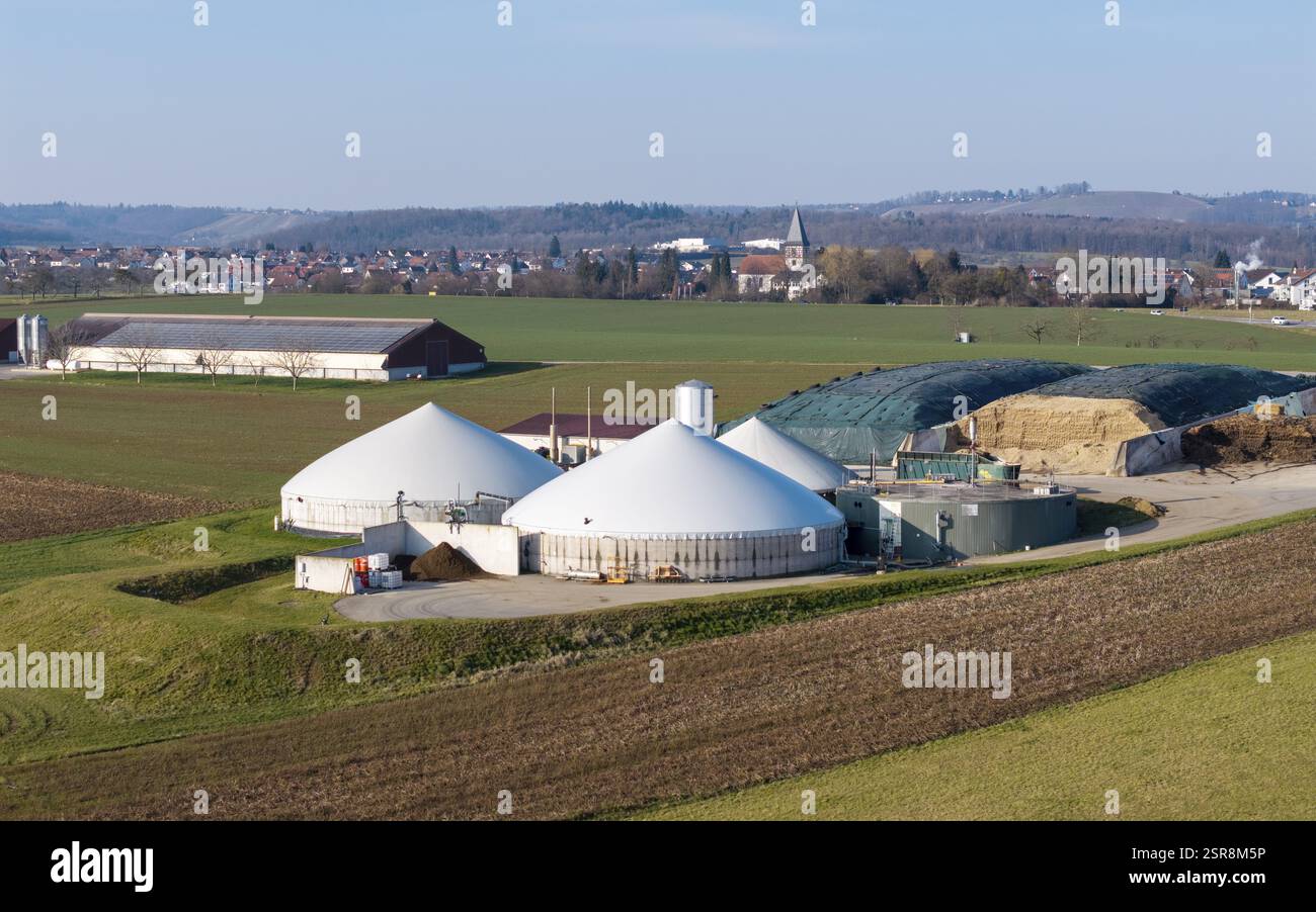 Modern biogas plant in a rural setting with a view of a village and ...
