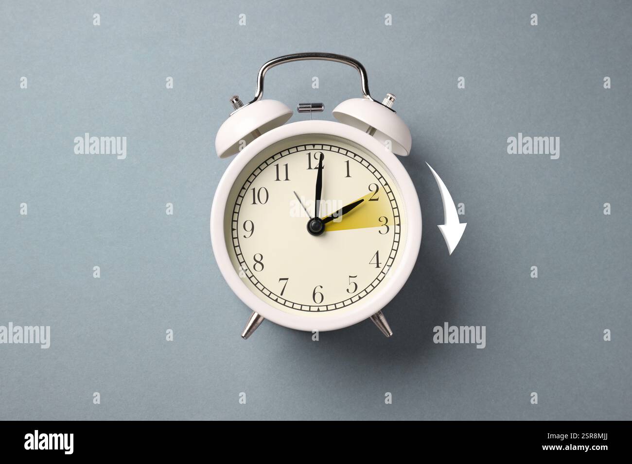 Daylight saving time. White alarm clock on grey background, top view ...