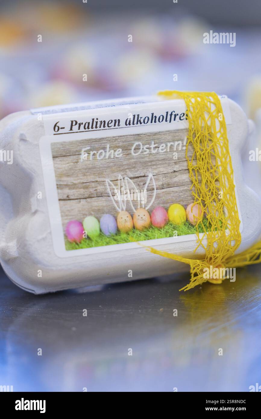 Wrapped chocolates in an egg carton with colourful Easter decorations ...