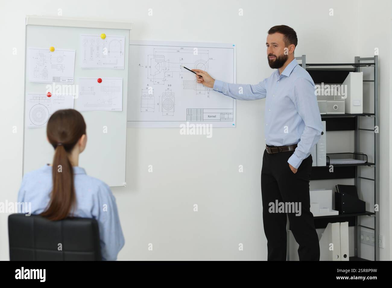 Man making presentation with engineering drawings to his colleagues in ...