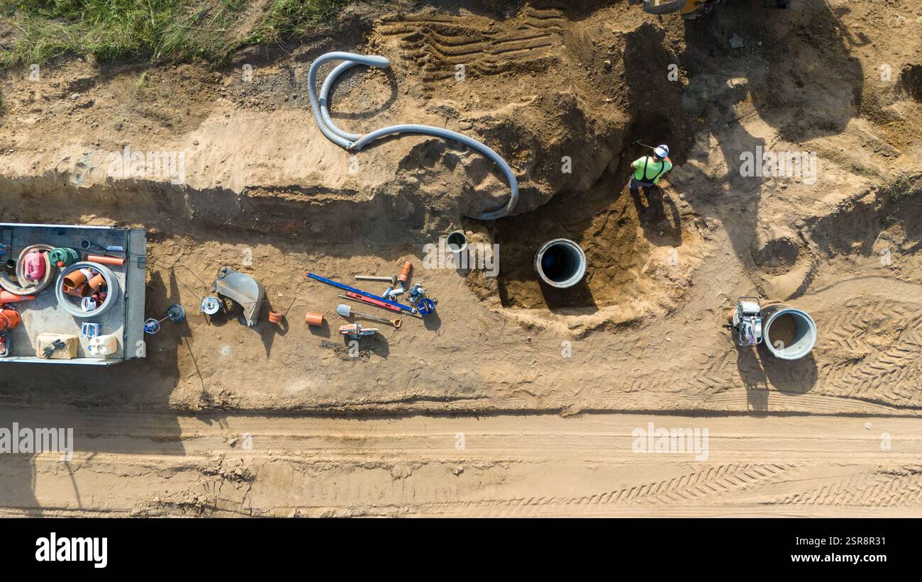Aerial view of a construction site with workers installing underground ...