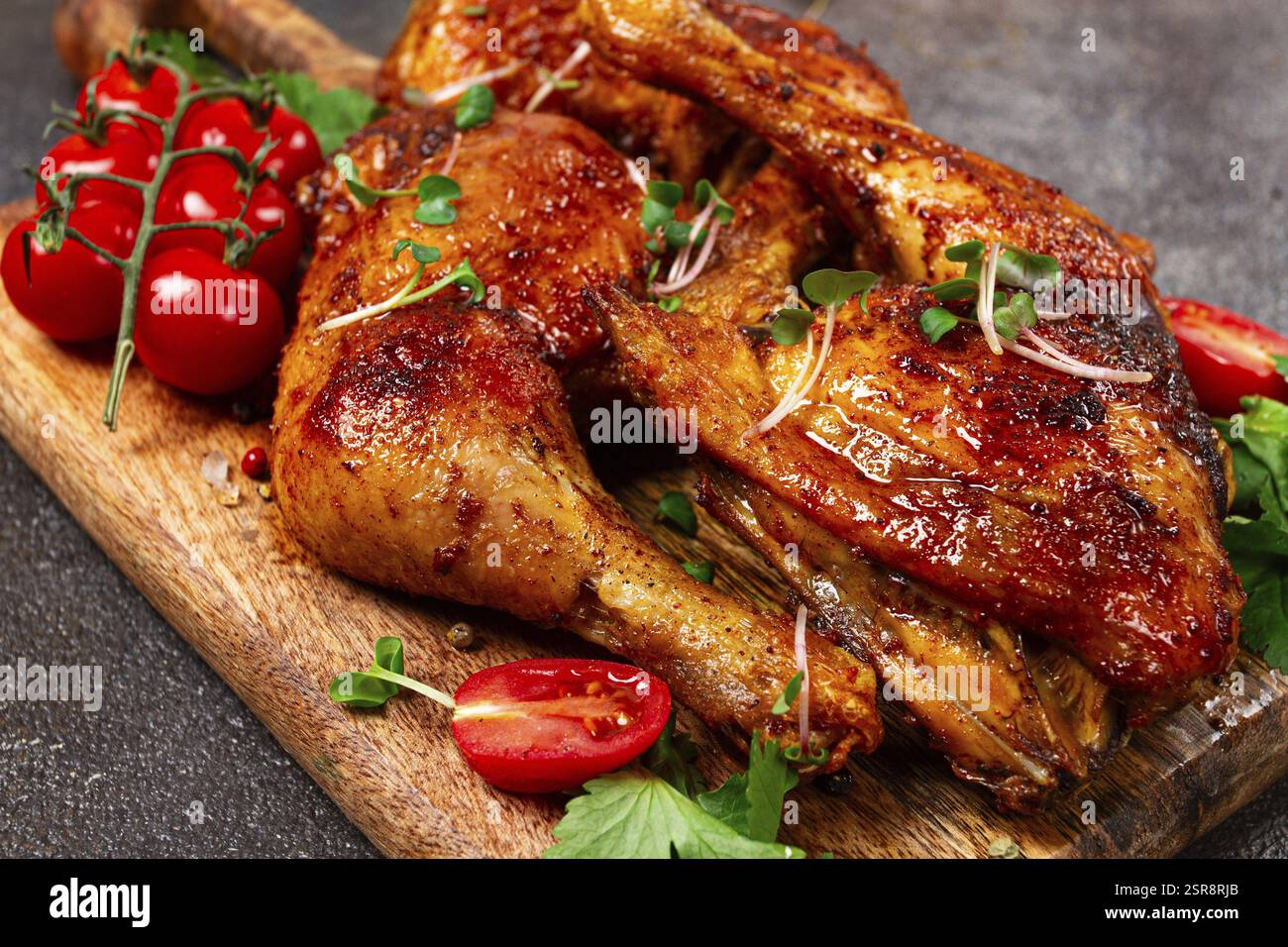 Grilled fried chicken legs, served with fresh cherry tomatoes, and ...