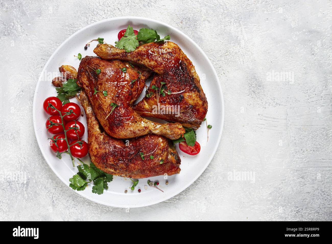 Grilled fried chicken legs, served, with fresh cherry tomatoes, and ...