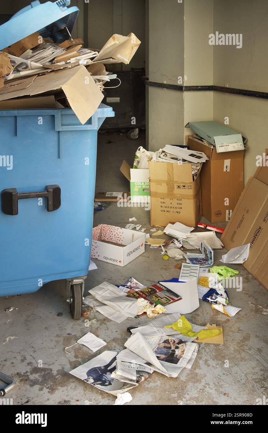 Overfilled blue paper bin, paper waste on the floor Stock Photo - Alamy