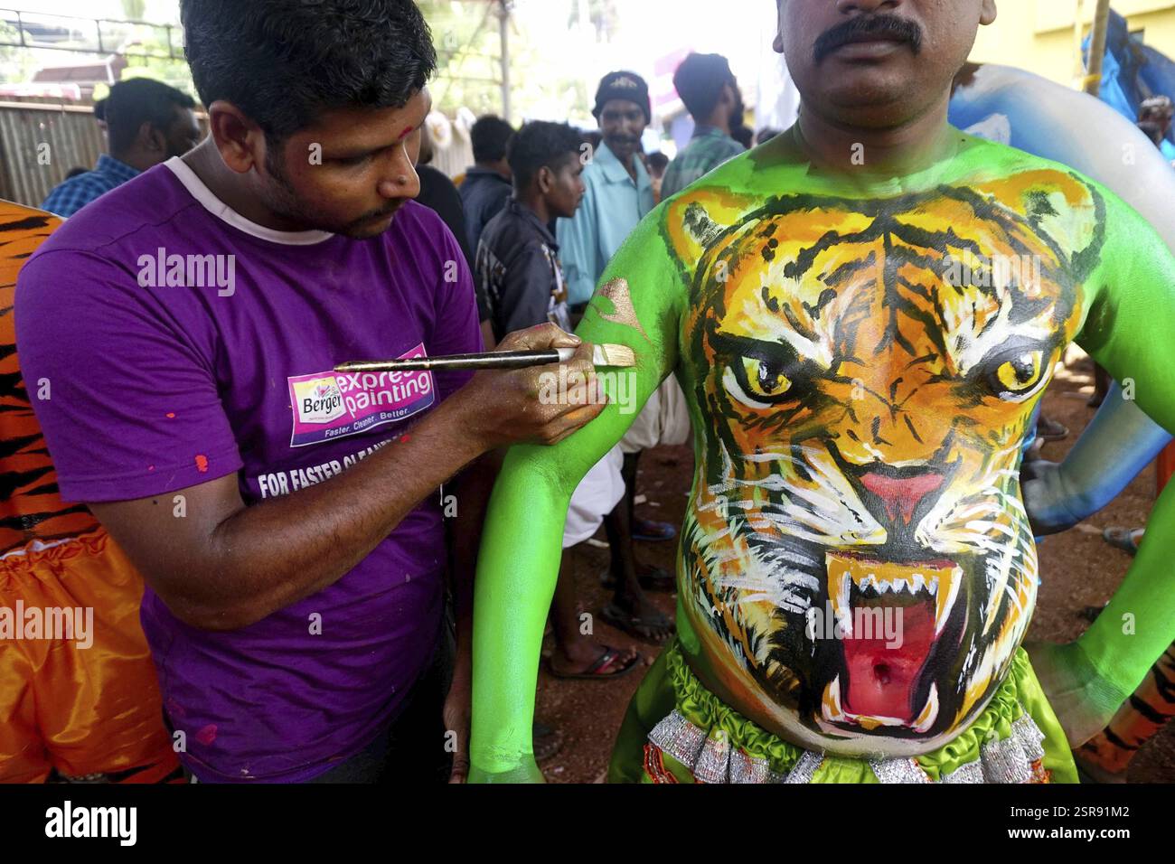 A trained dancer gets his body painted in the colours tiger prepares to ...
