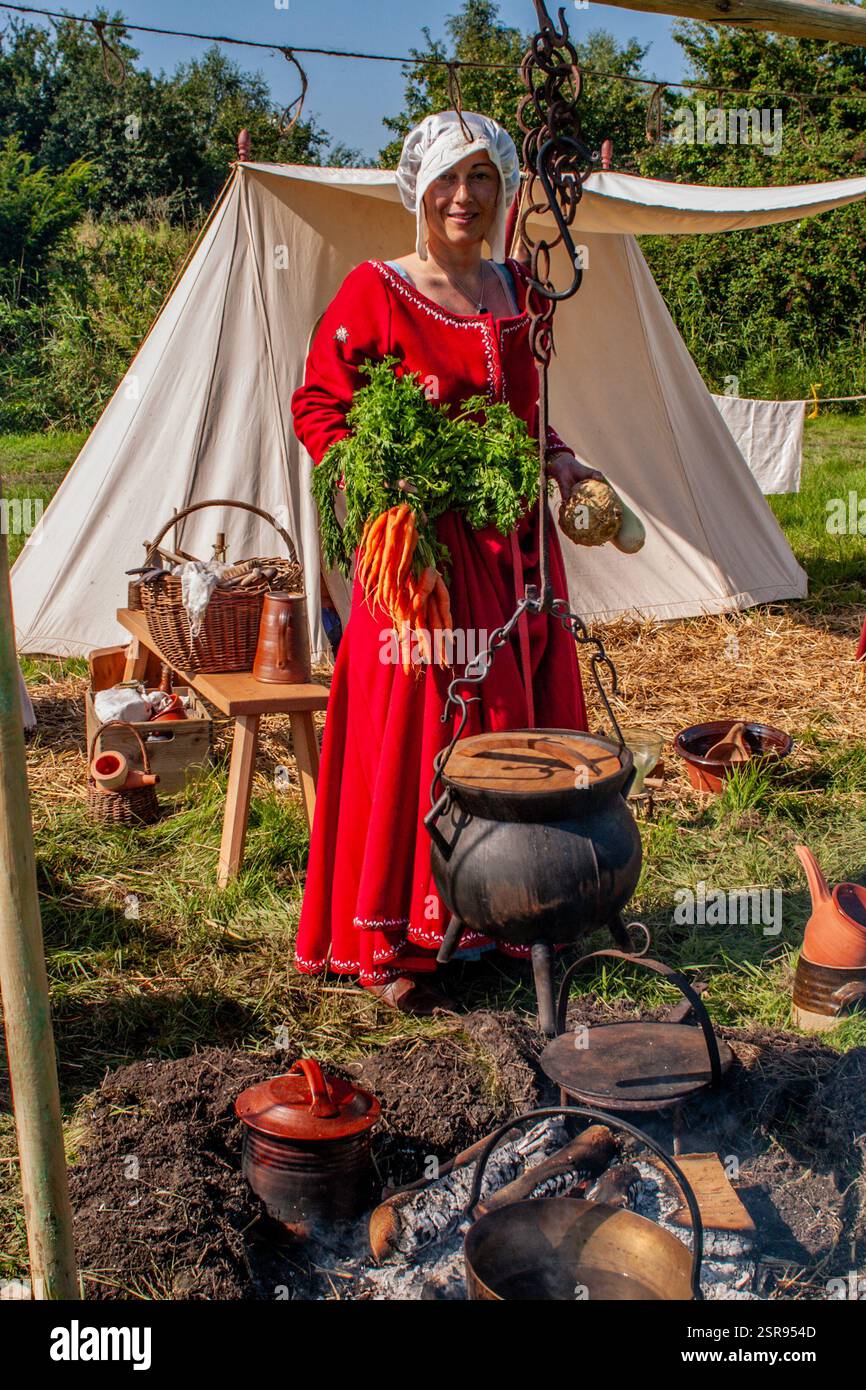 Historical re-enactment and medieval fayre with lady preparing a meal ...