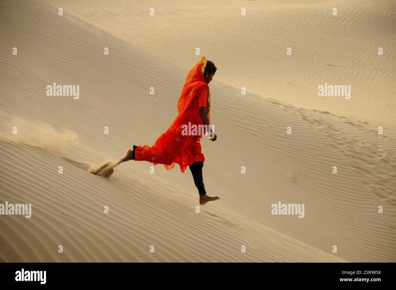 Rajasthani lady walking down from sand dunes, Jaisalmer, Rajasthan ...
