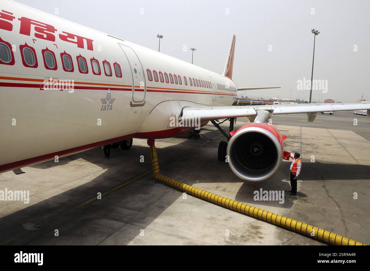 Mechanic checking engine and pumping fuel in aircraft at indira gandhi ...