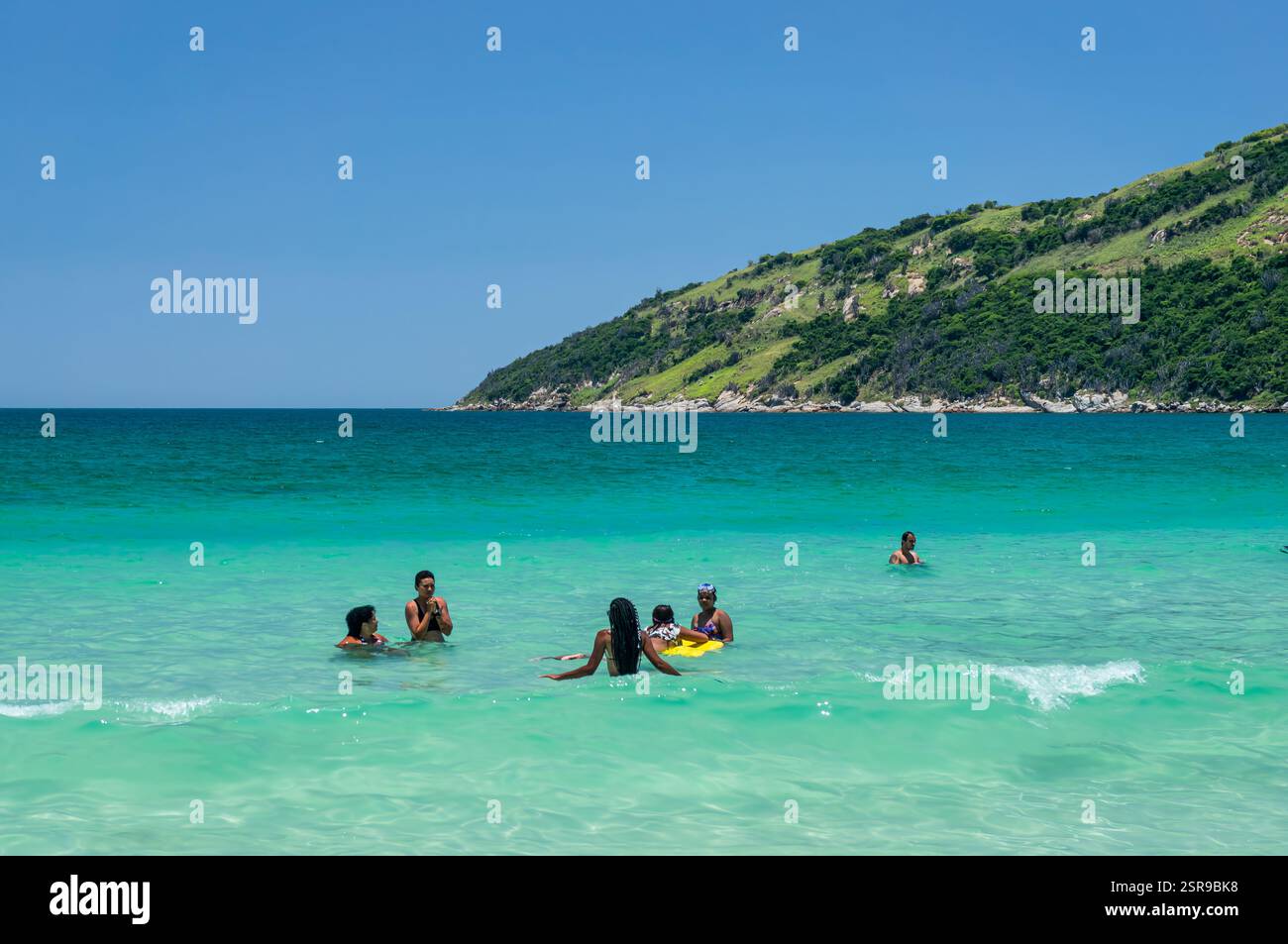 Tourists swimming and relaxing in the crystal clear blue waters of the ...