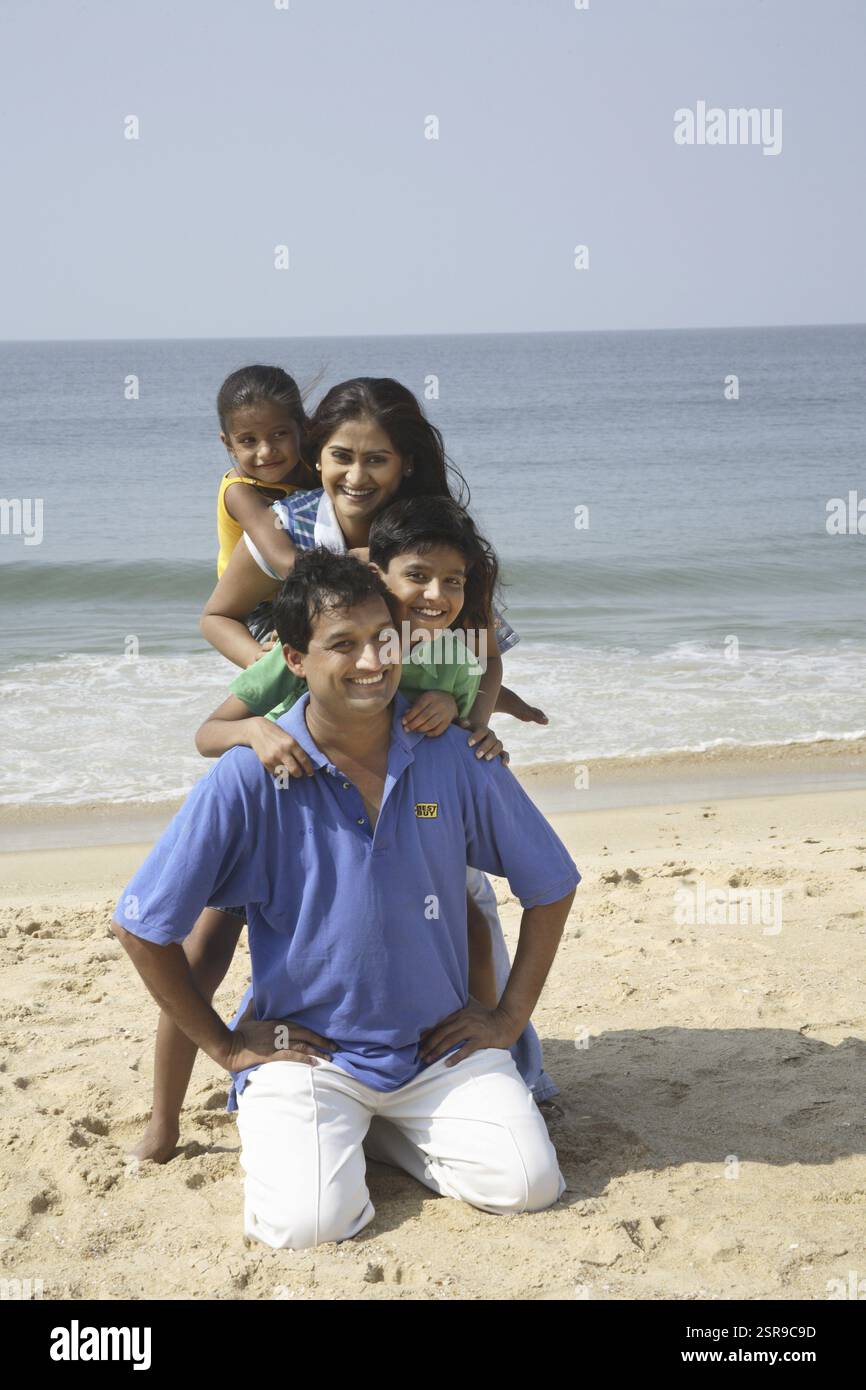 South Asian Indian parent and children standing behind each other on ...
