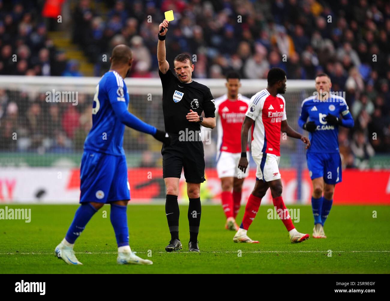 Referee Sam Barrott shows a yellow card to Leicester City's Jordan Ayew ...