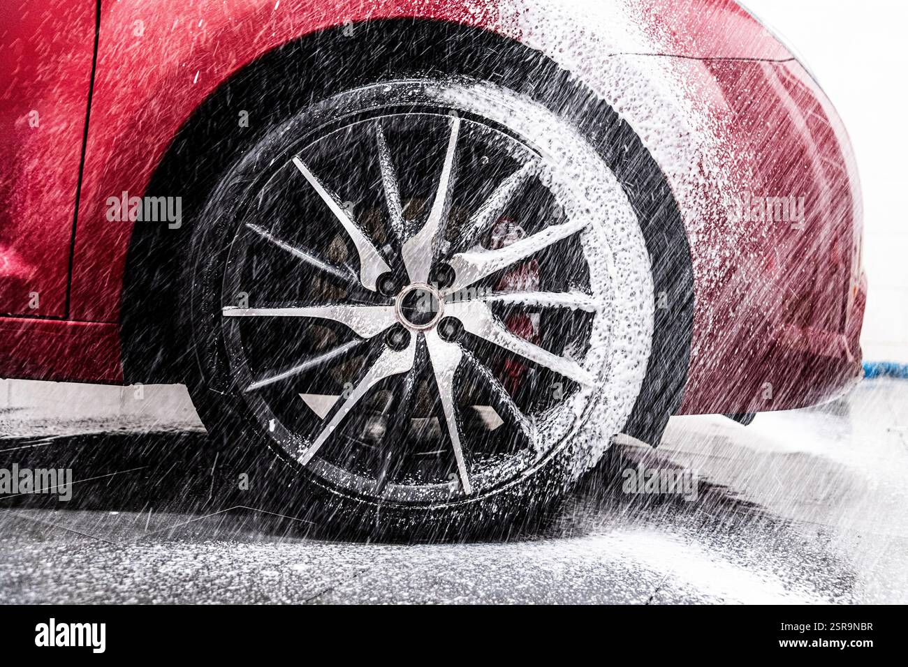 Red car and wheel covered in thick active foam for a deep, thorough ...