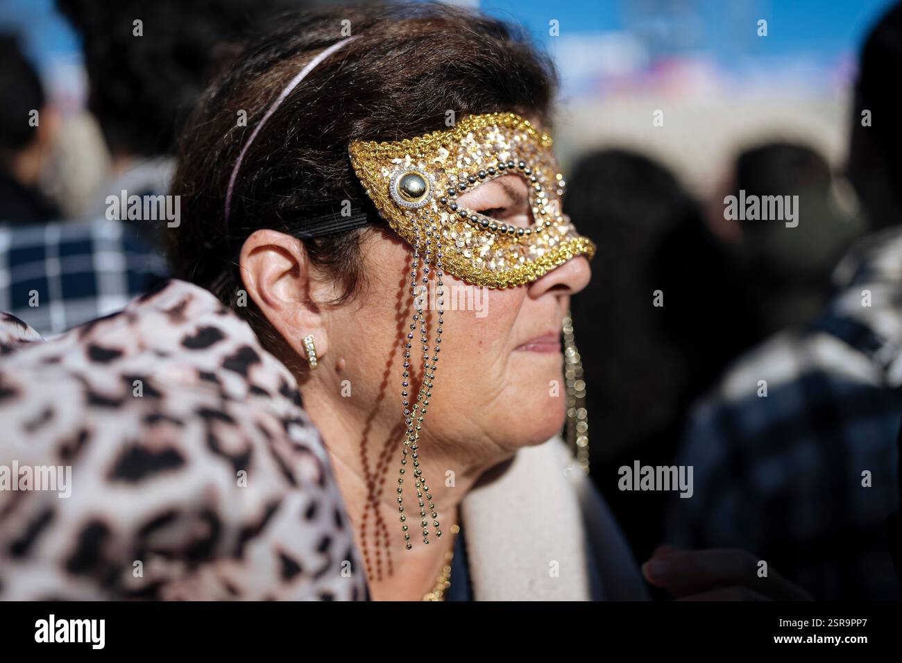 A masked lady walks along Place Massena prior to the opening ceremony ...