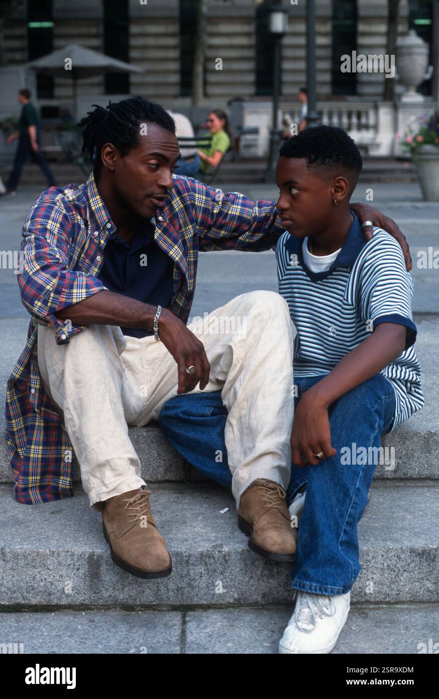 Father having a serious talk with his adolescent son in Bryant Park, in ...