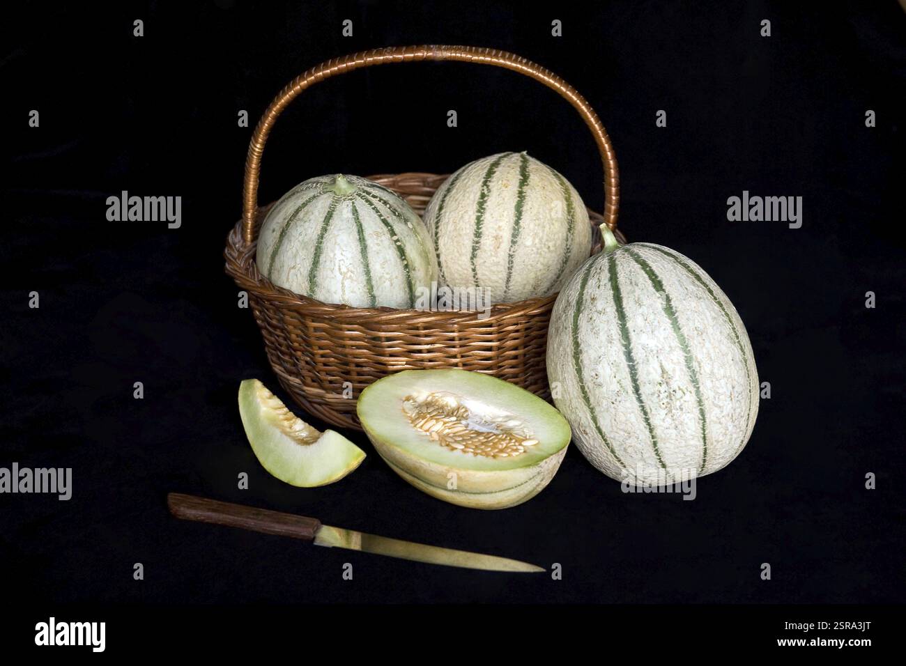 Three full and one cut charentais melon with cane basket, India, Asia ...