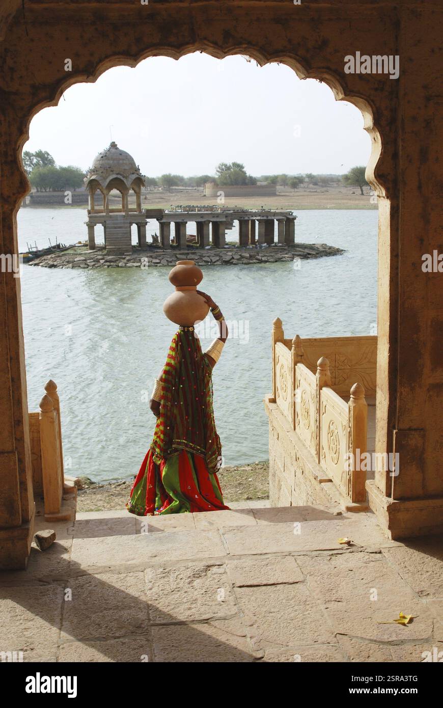A woman in traditional Rajasthani dress with pitchers on her head ...