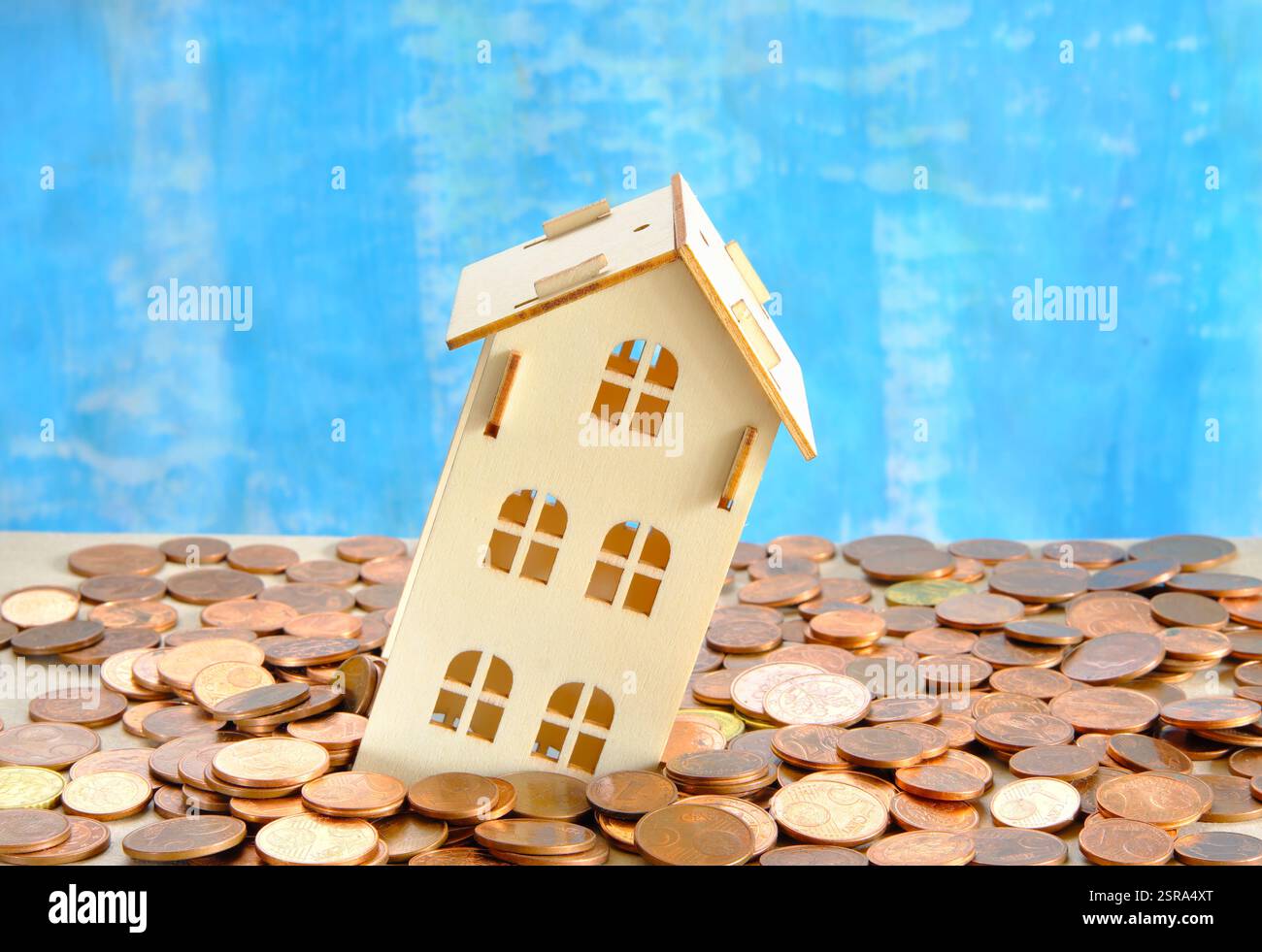 rising costs of building of a house, model house under construction and stacks of money ...