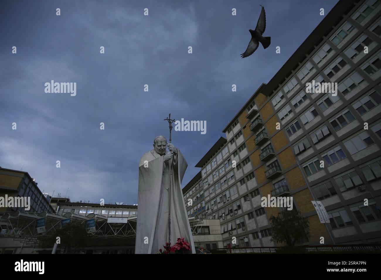 A marble statue of late Pope John Paul II is backdropped by the ...