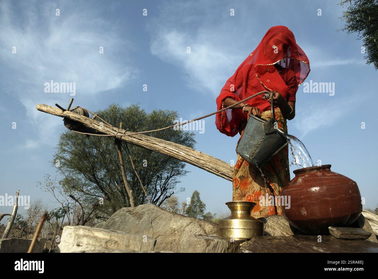 Rajasthani lady fetch drinking water from well pouring in pot ...