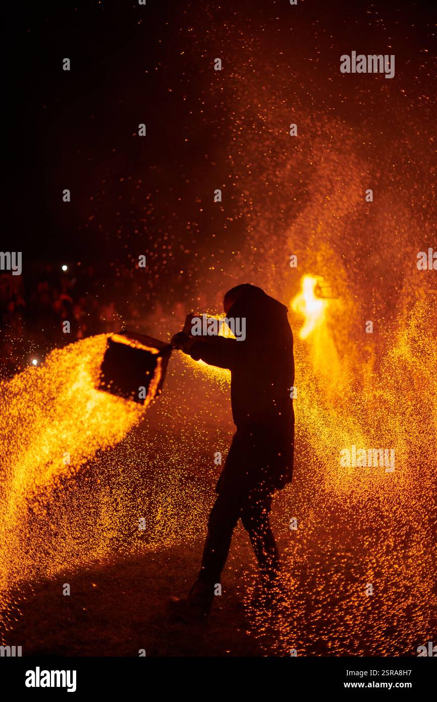 Silhouette of two fire performers with sparkling fire staff erupting in ...