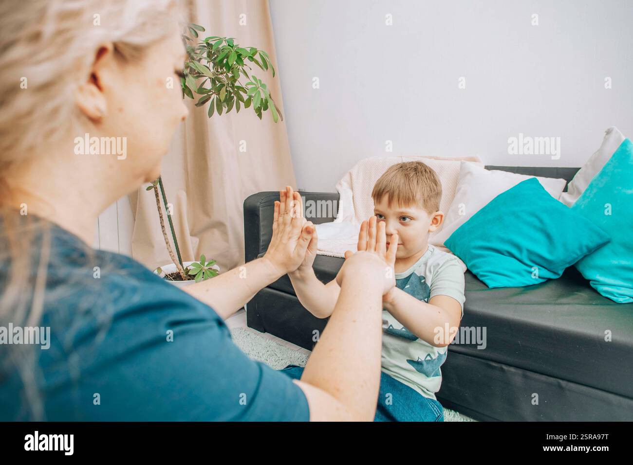 female therapist and boy practicing hand gestures in therapy session ...