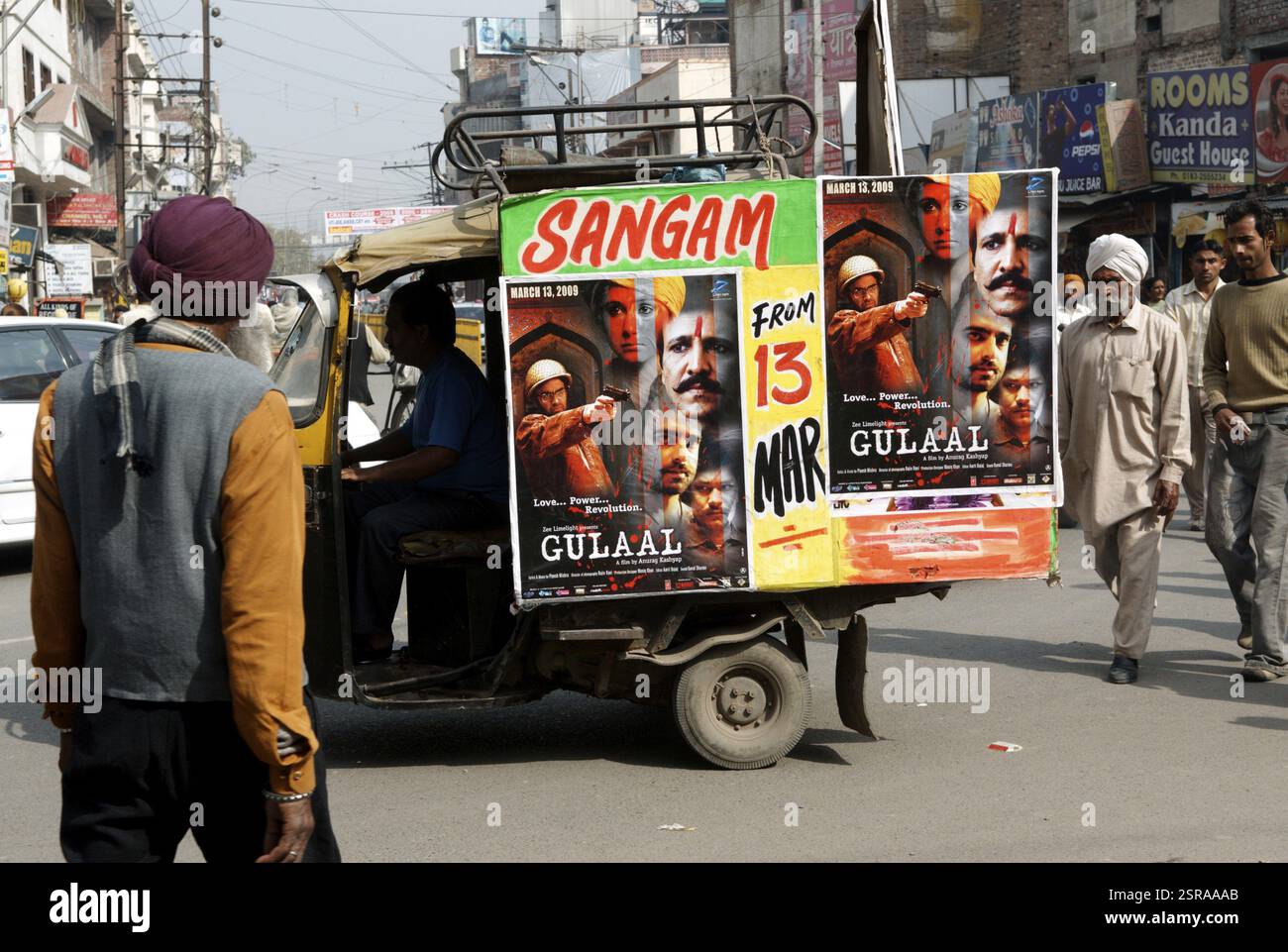 View of auto rickshaw carrying film poster for promotion on busy ...