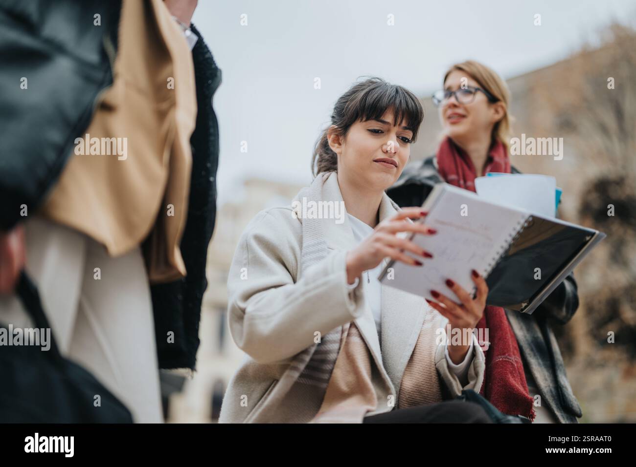 Group of businesswomen discussing and reviewing documents outdoors ...