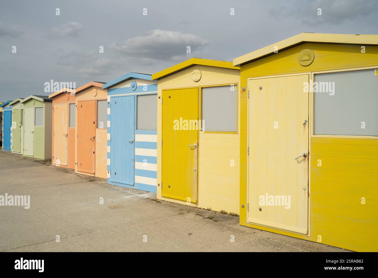 Colorful beach huts (or beach cabins) line the promenade at Seaford UK ...