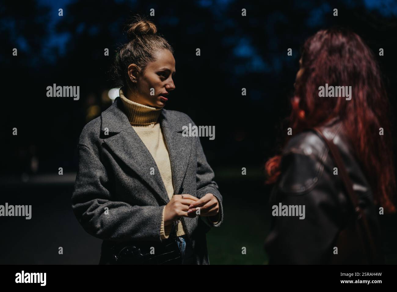 Two Women Having a Serious Conversation Outdoors at Night Stock Photo ...