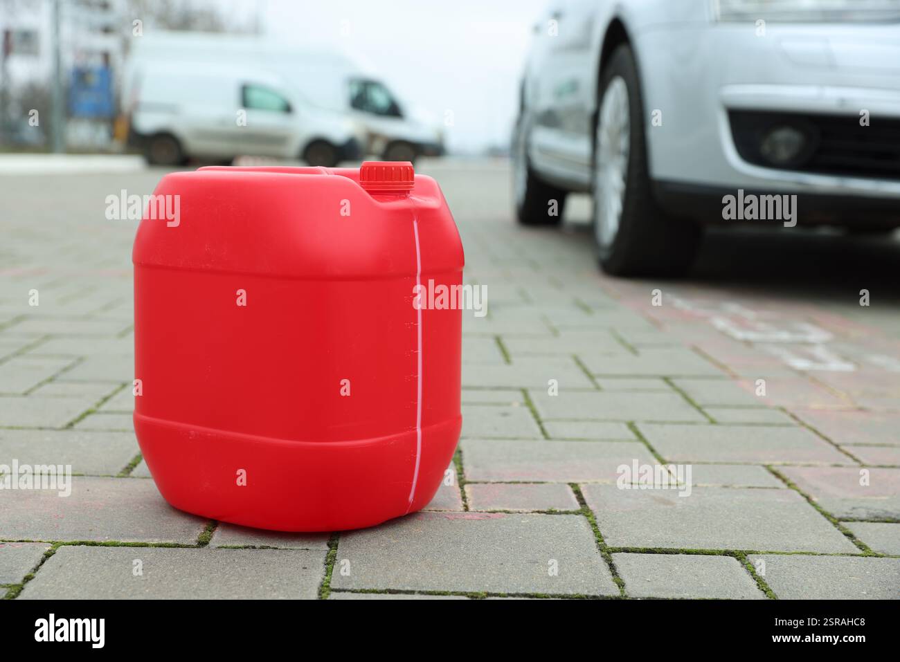 One red plastic canister on pavement outdoors Stock Photo - Alamy