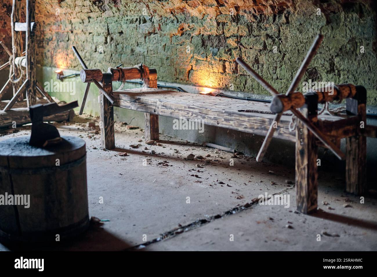 Wooden medieval torture rack with ropes and cranks in stone walled ...
