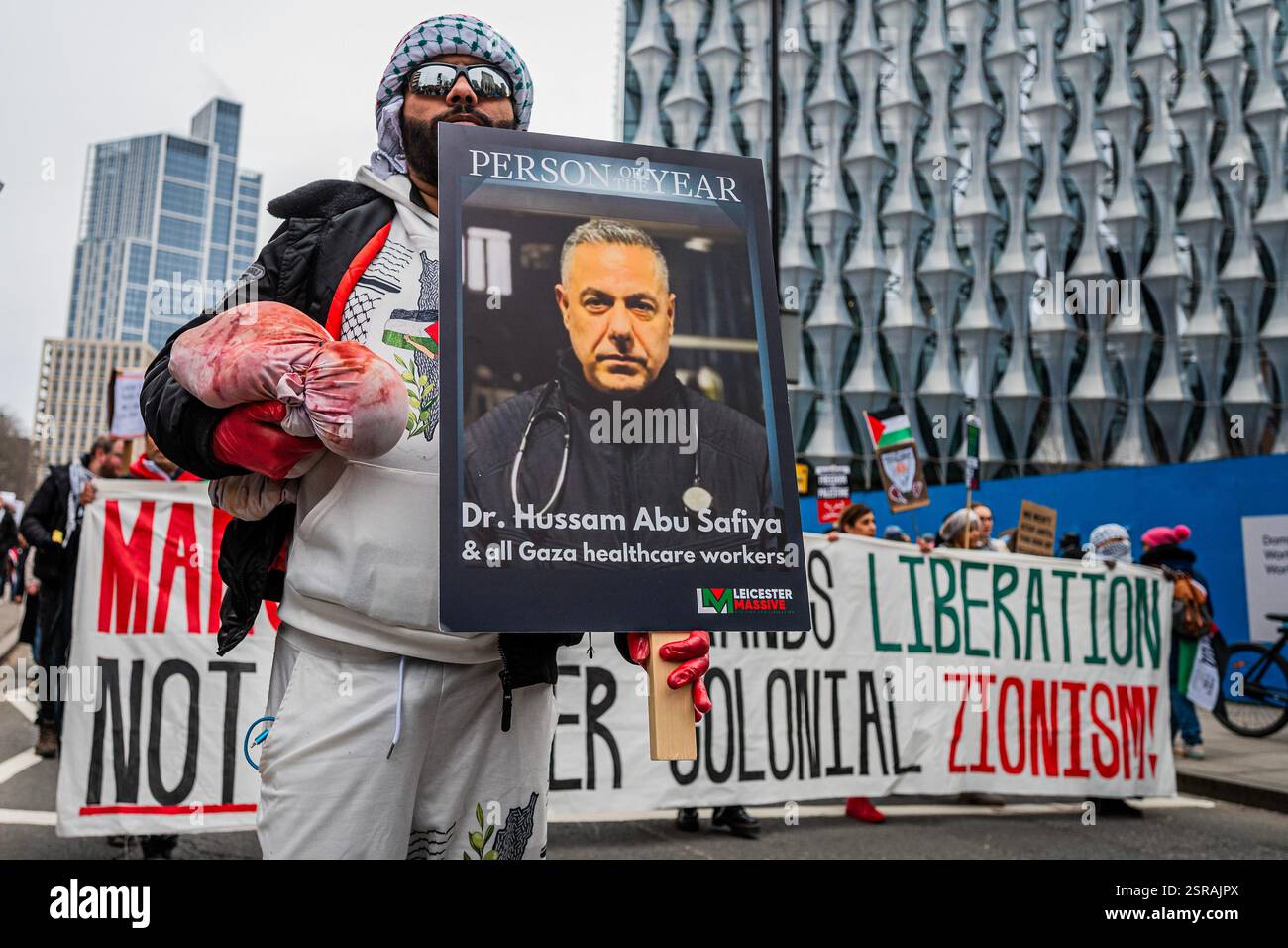 London, UK. 15 Feb 2025. People carry 'blood' stained packages to ...