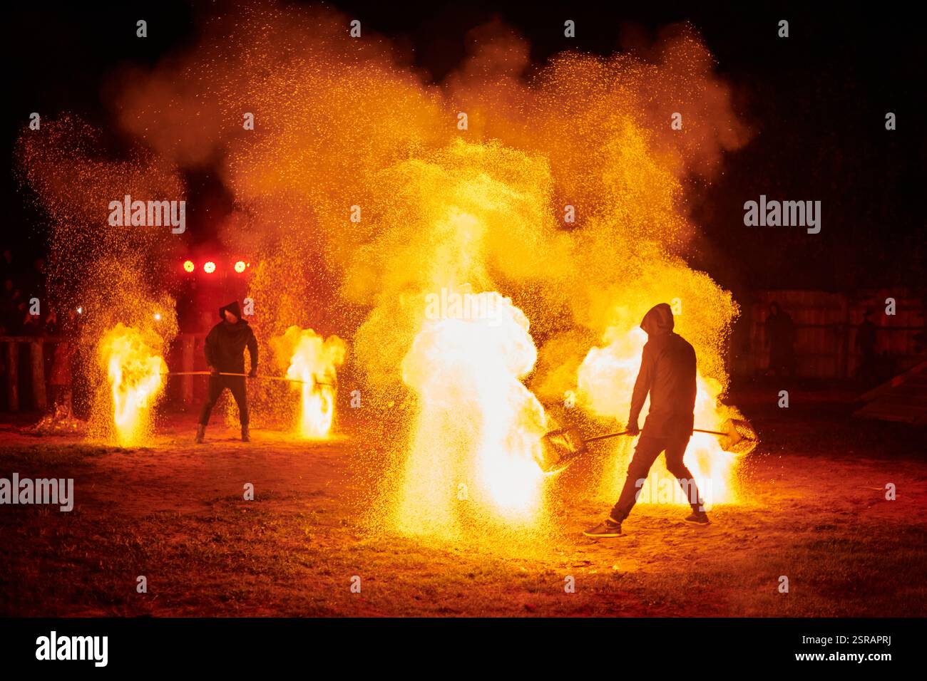 Silhouette of two fire performers with sparkling fire staff erupting in ...