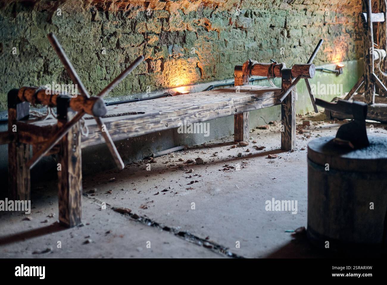 Wooden medieval torture rack with ropes and cranks in stone walled ...