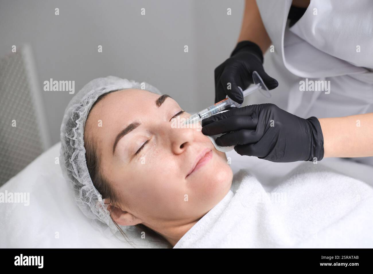 Female patient undergoes cosmetic injection by professional in clinical ...