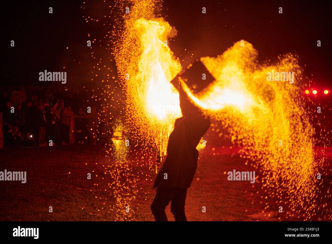 Silhouette of two fire performers with sparkling fire staff erupting in ...