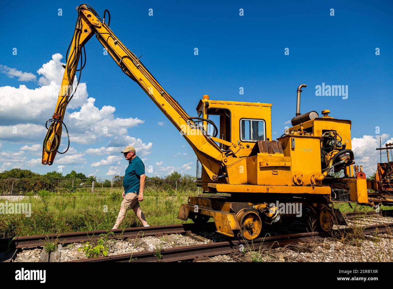 A man walks past a vintage railroad tie crane on display at the Fort ...