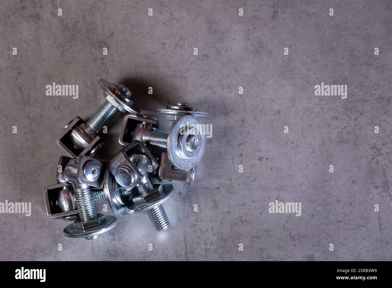 Various types of metal fasteners displayed on a concrete surface for ...