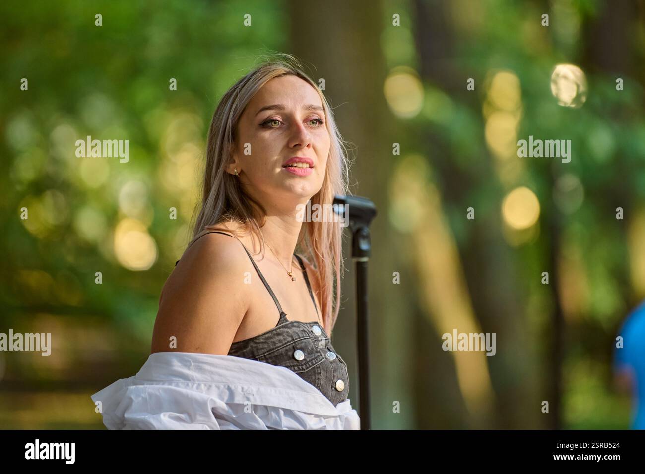 Kaliningrad, Russia - 10.08.2024 - Young woman sings into microphone in ...