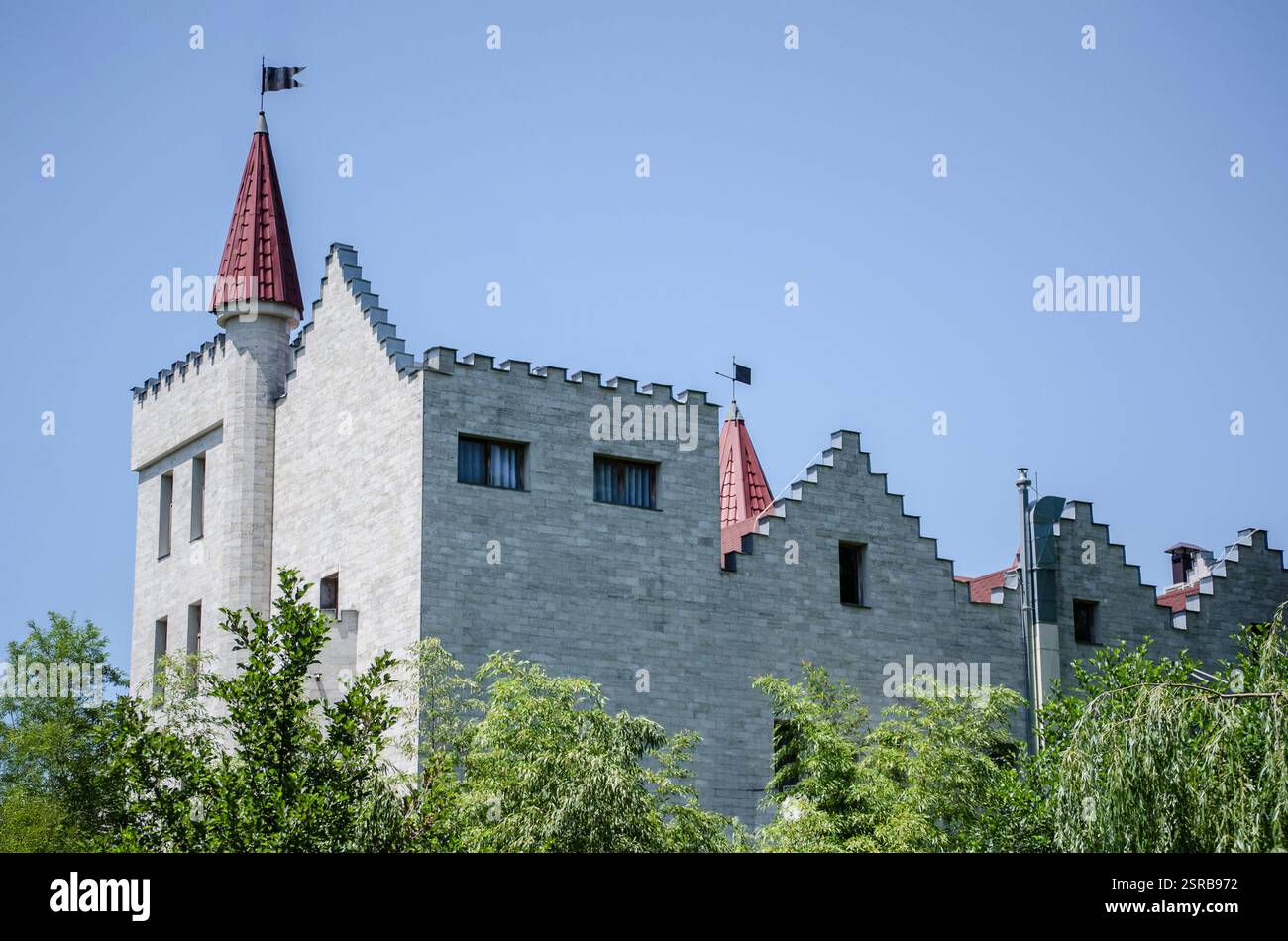 Stone castle features red-tiled conical towers and crenelated walls ...