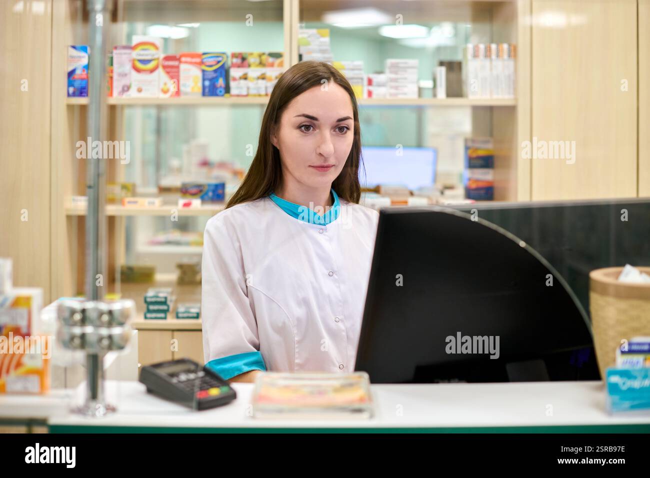 Young female pharmacist with long brown hair, neutral expression ...