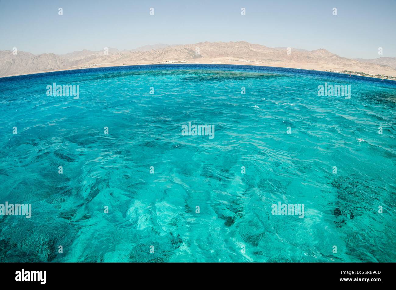 Red sea displays stunning turquoise waters under clear sky. Rugged ...
