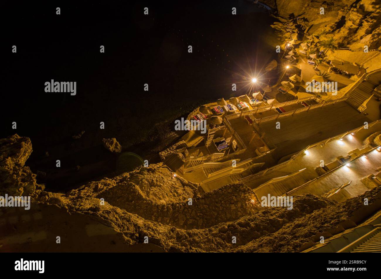 Cliffside resort illuminated by warm lights at night. Elevated ...