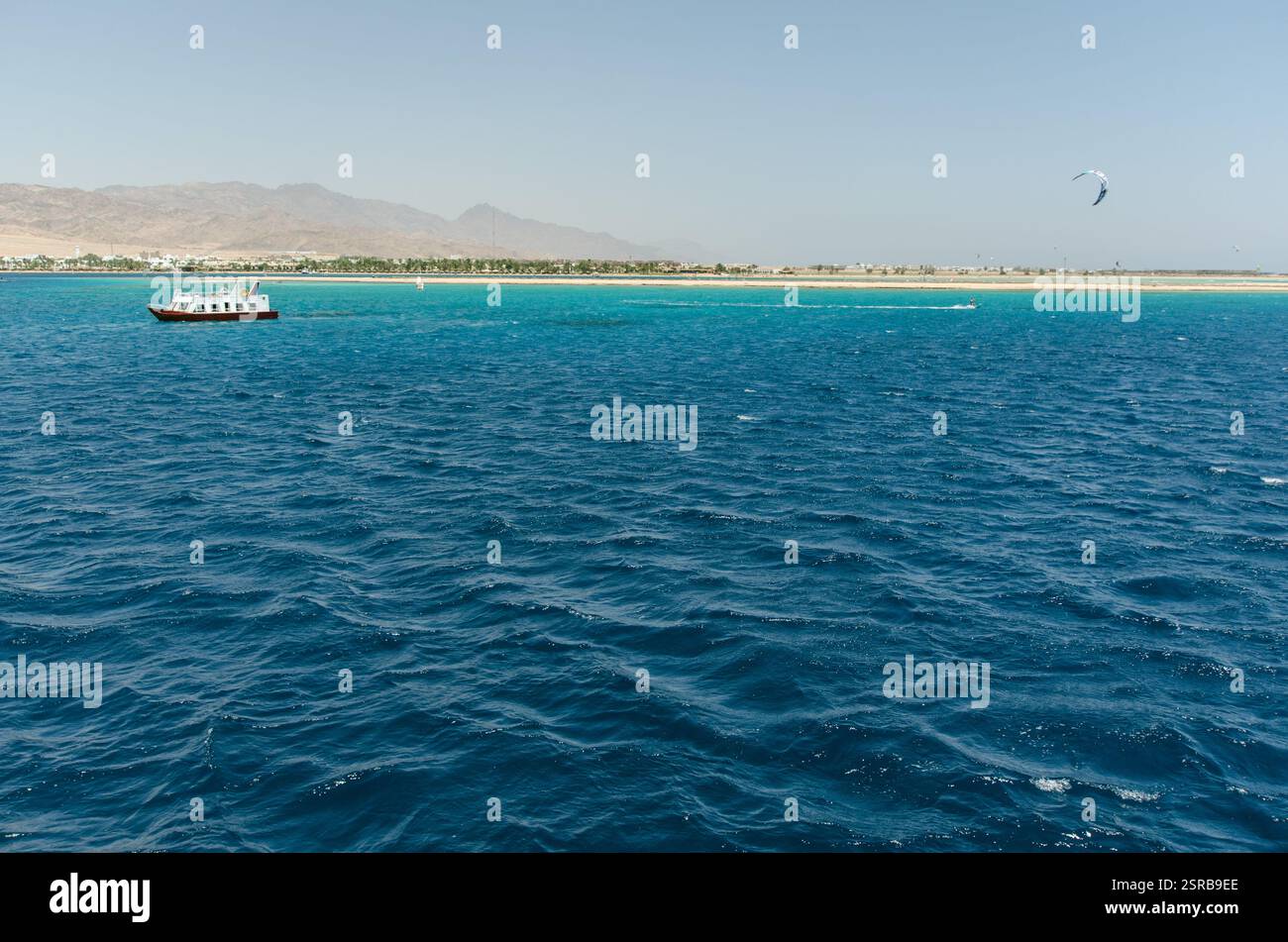 Expansive, vibrant Red Sea stretches under clear skies. Boat gently ...