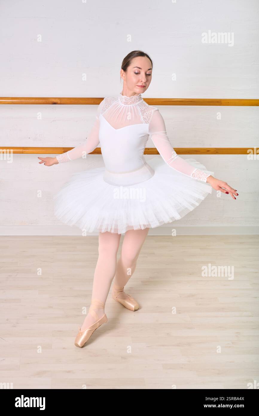 Young adult female with brown hair in white tutu performing elegant ...